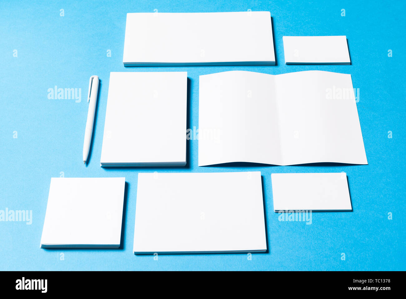 blank office objects organized for company presentation on blue paper ...