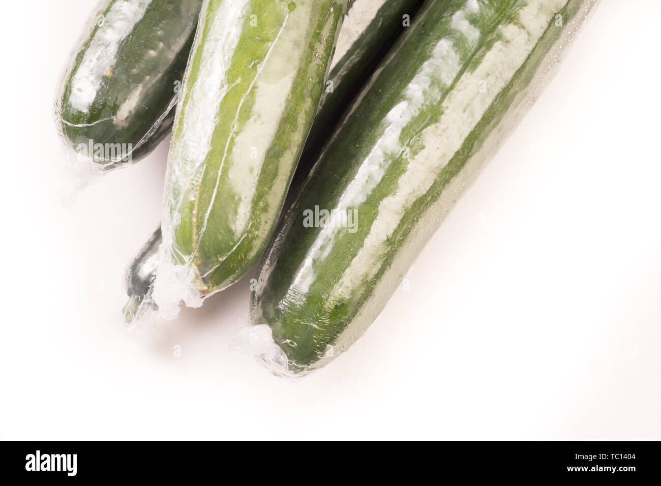 Bunch of cucumber wrapped in plastic films, isolated on white ...