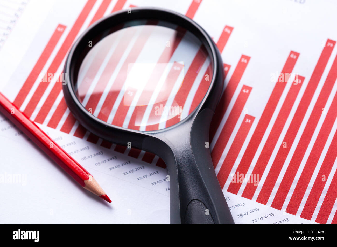 financial documents with magnifying glass over them Stock Photo - Alamy