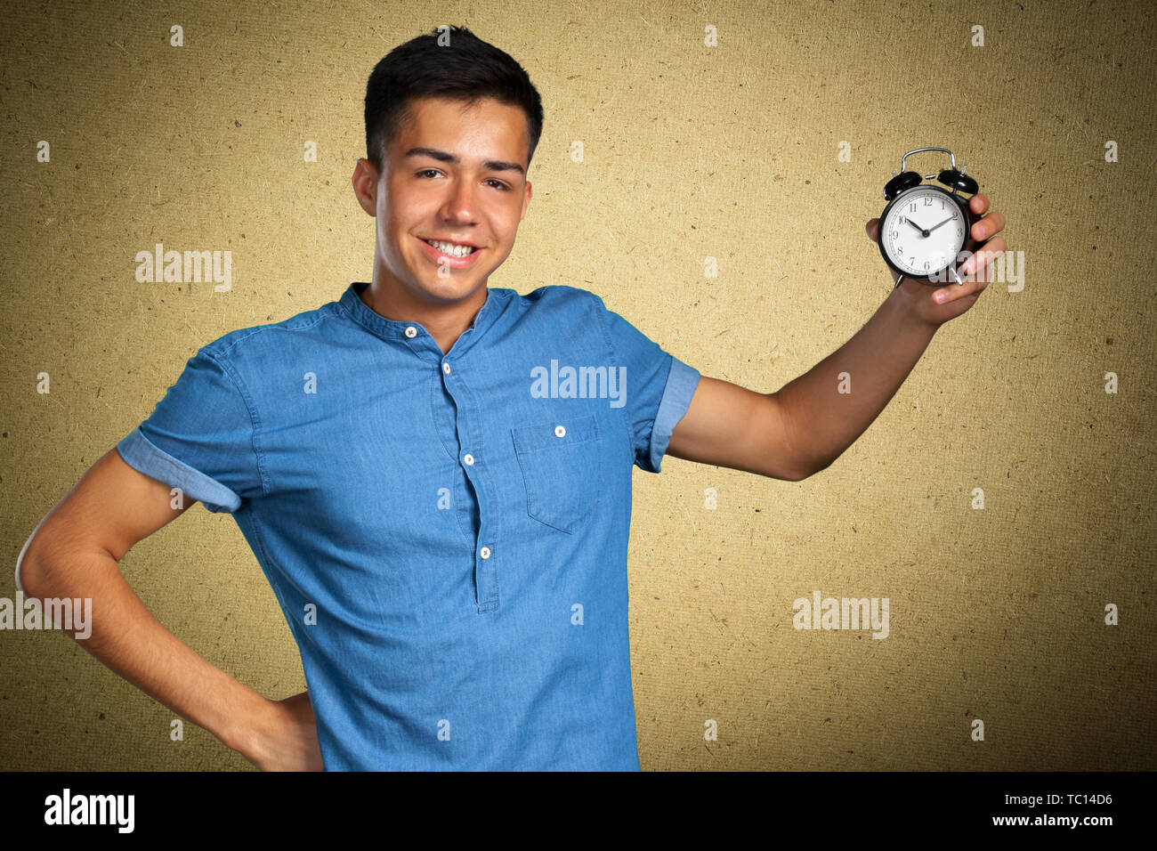 young man holding an alarm clock Stock Photo - Alamy