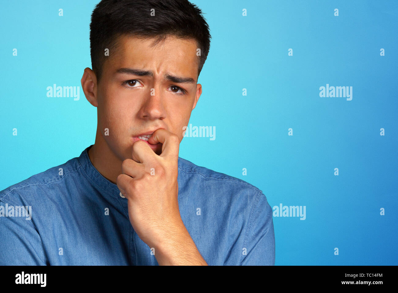 Young hispanic man biting fingernails hi-res stock photography and ...