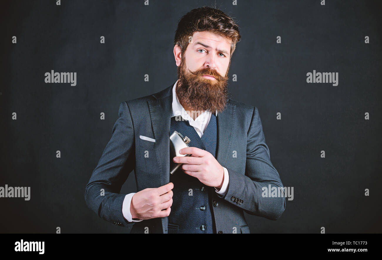 Man bearded hipster wear elegant suit hold metal flask for alcohol. Guy ...
