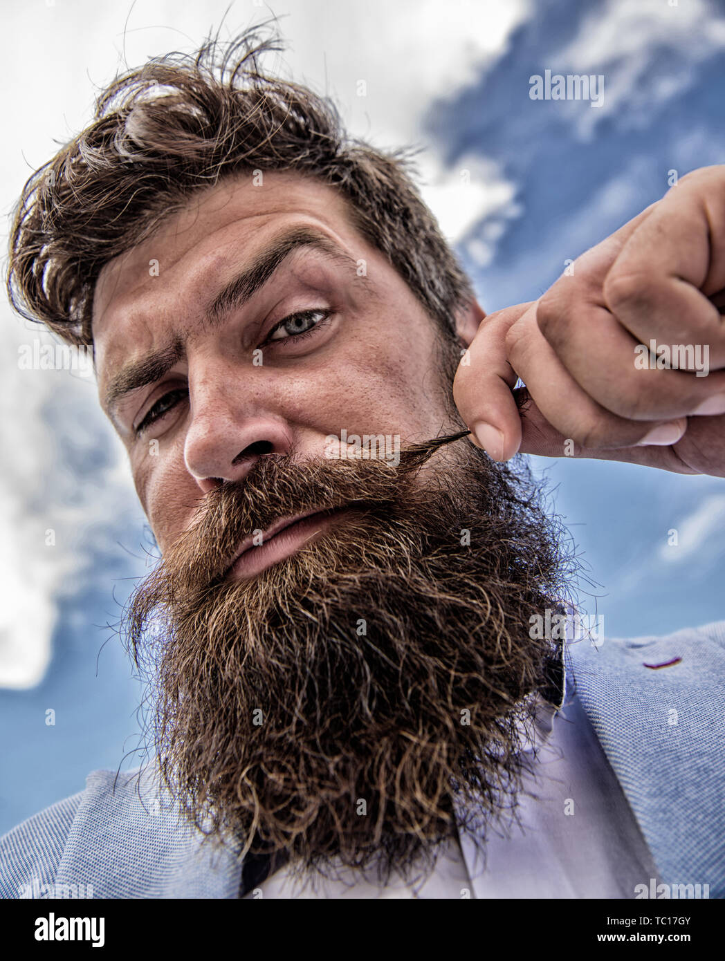 Hipster handsome attractive guy close up. Man bearded hipster twisting ...