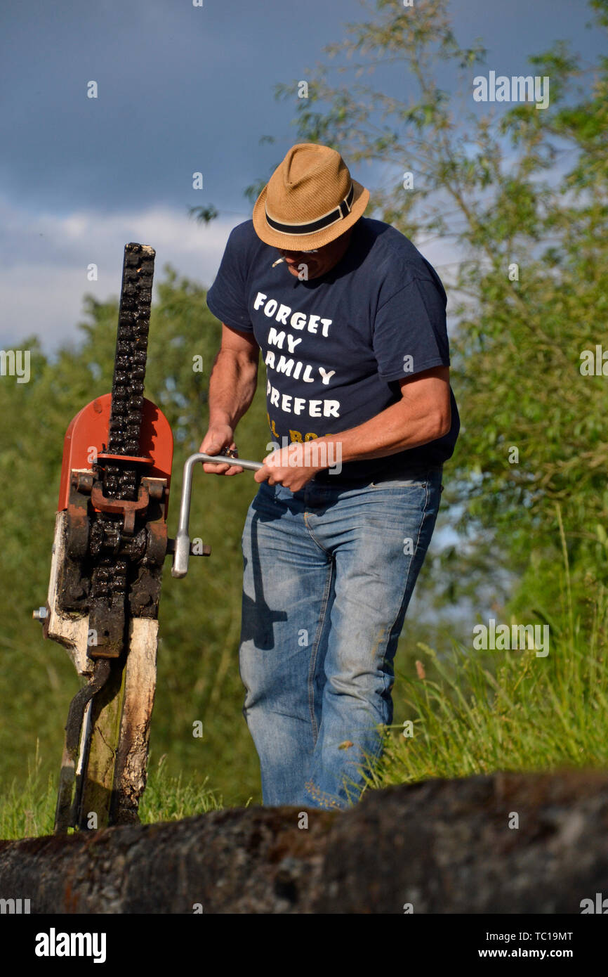 Skipper cranking the lock handle on the Grand Union Canal, Aylesbury ...