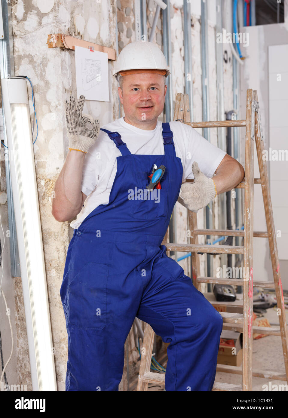 Happy confident professional builder posing in repairable room Stock ...