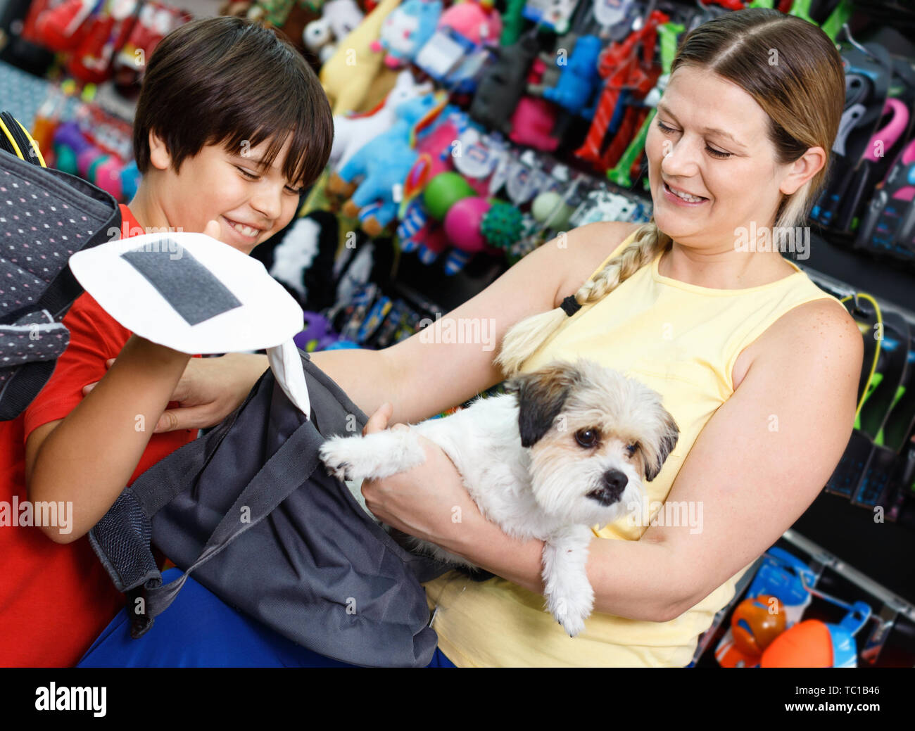 Careful cheerful smiling family visiting pet shop in search of bag for ...