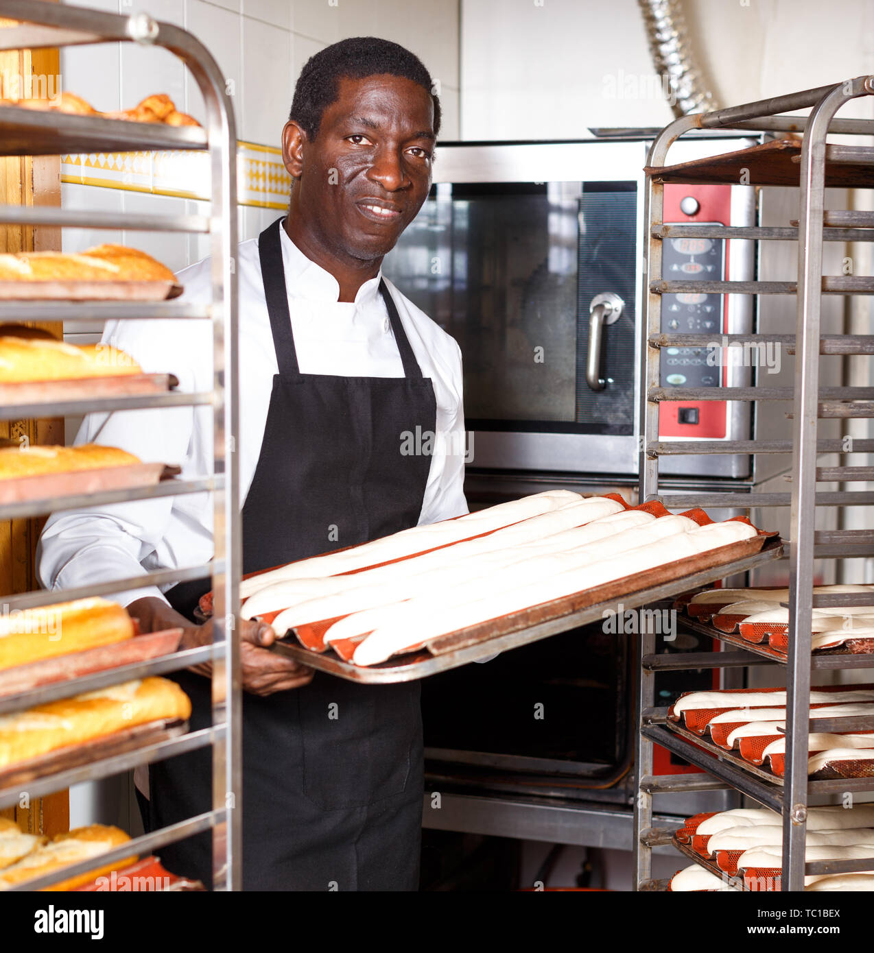 Portrait of experienced professional baker during daily work in kitchen ...