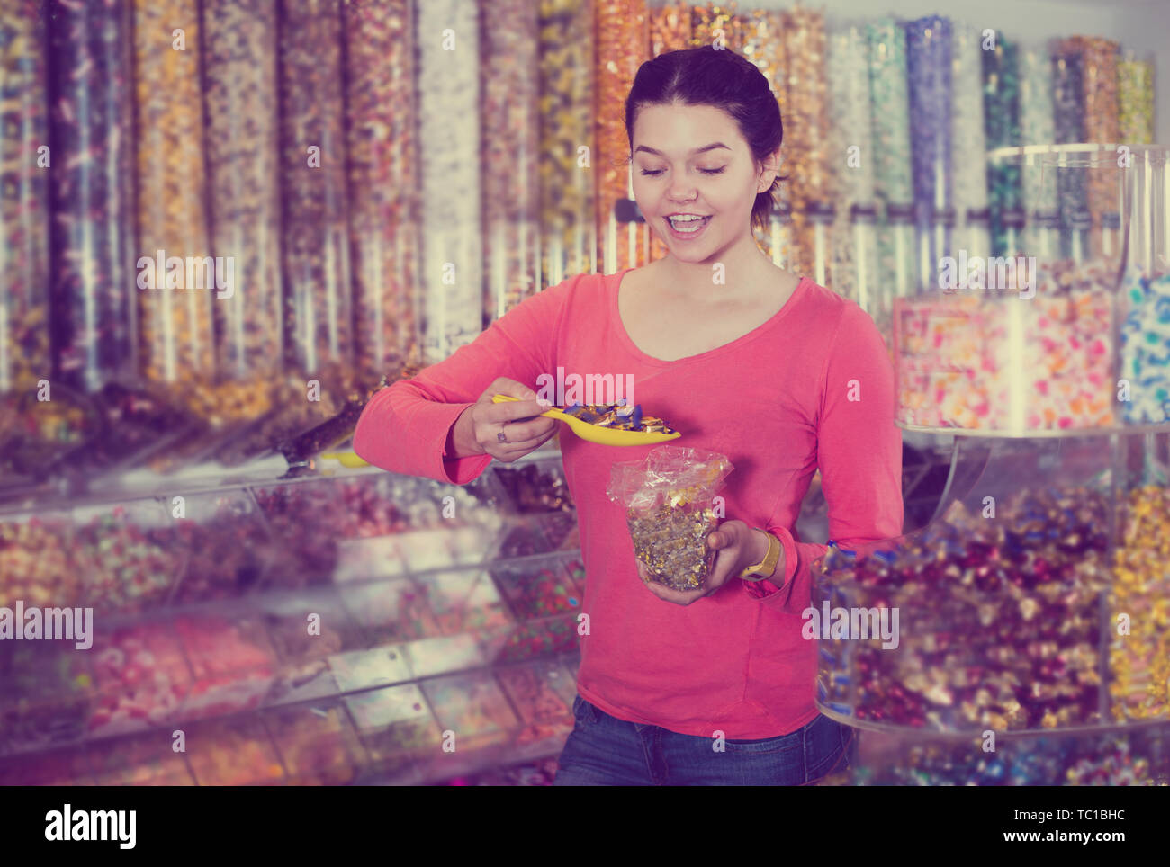 Shopgirl in store is picking up candies by the shovel into bag Stock ...