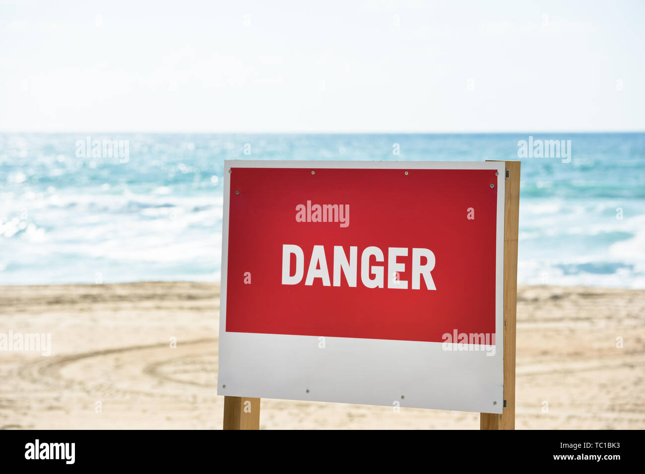 Red danger sign on an ocean beach with waves on the background. Strong ...