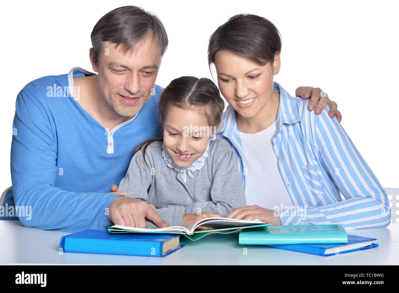 Happy parents and daughter doing homework on white background Stock ...