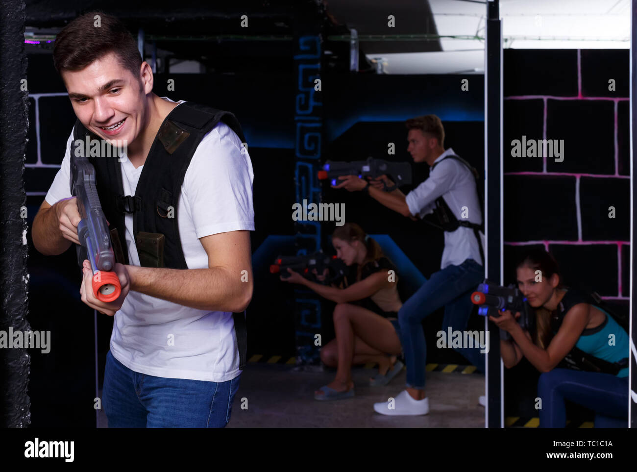 Portrait of happy guy with laser pistol and playing laser tag with his ...