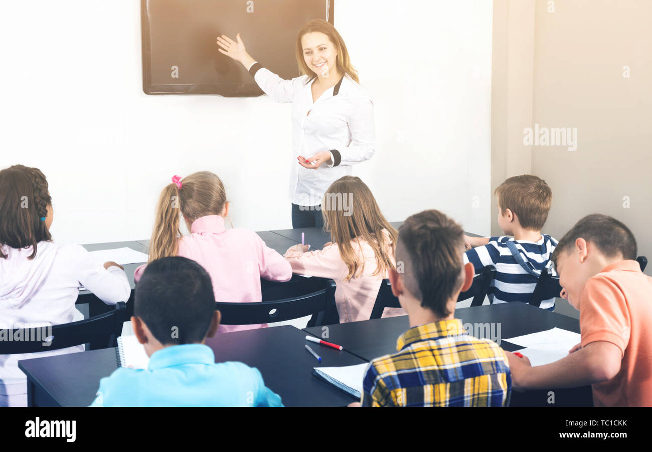 Professor and elementary age children in a classroom at school Stock ...