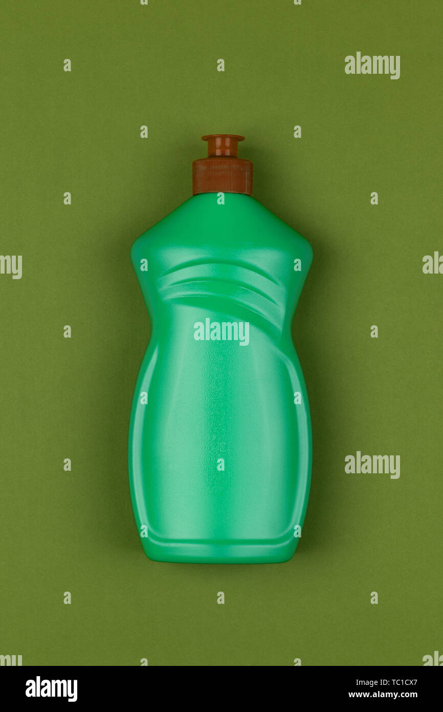 light green plastic bottle of dishwashing liquid on dark green ...