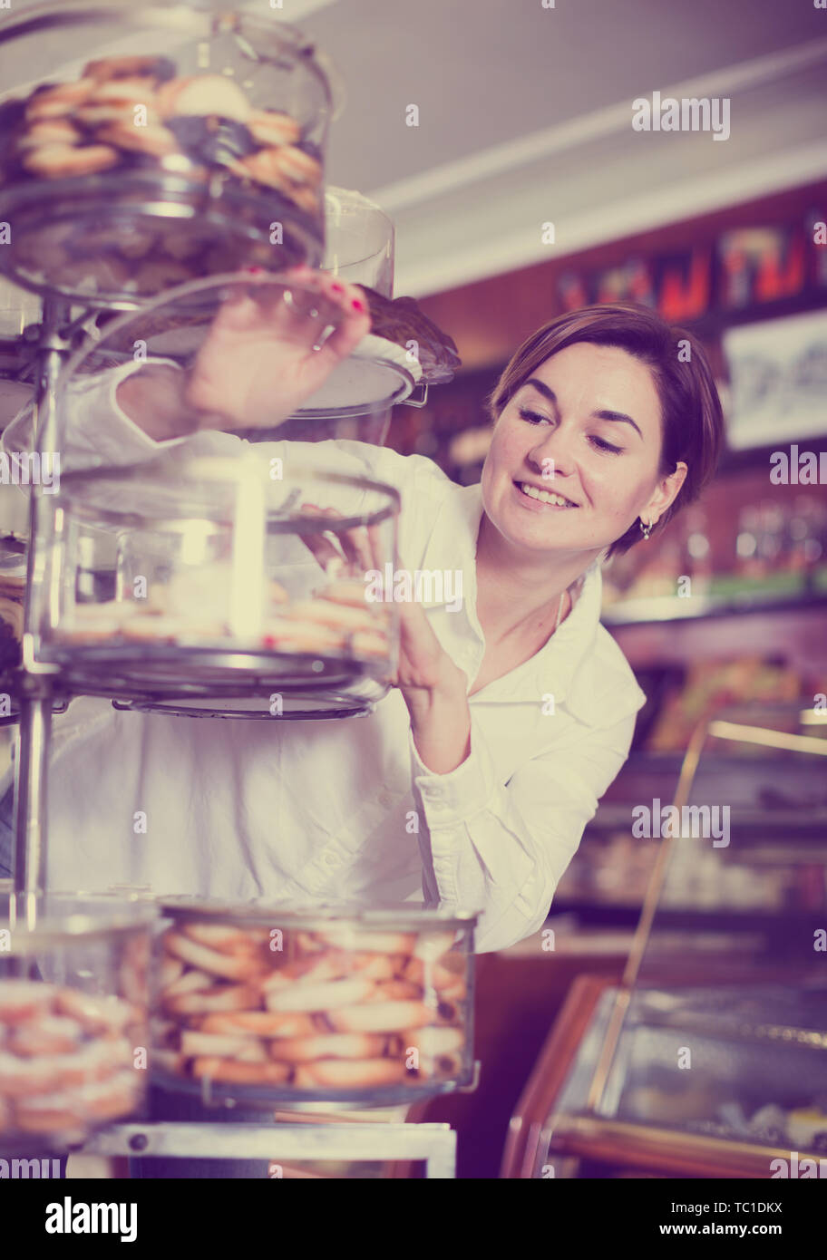 Young female customer examining desserts in confectionery Stock Photo ...