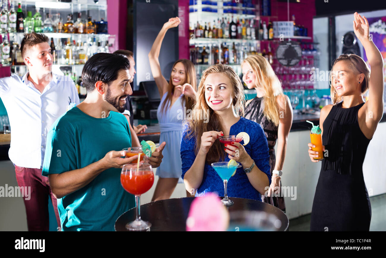 Happy cheerful positive smiling man with woman are drinking cocktails ...