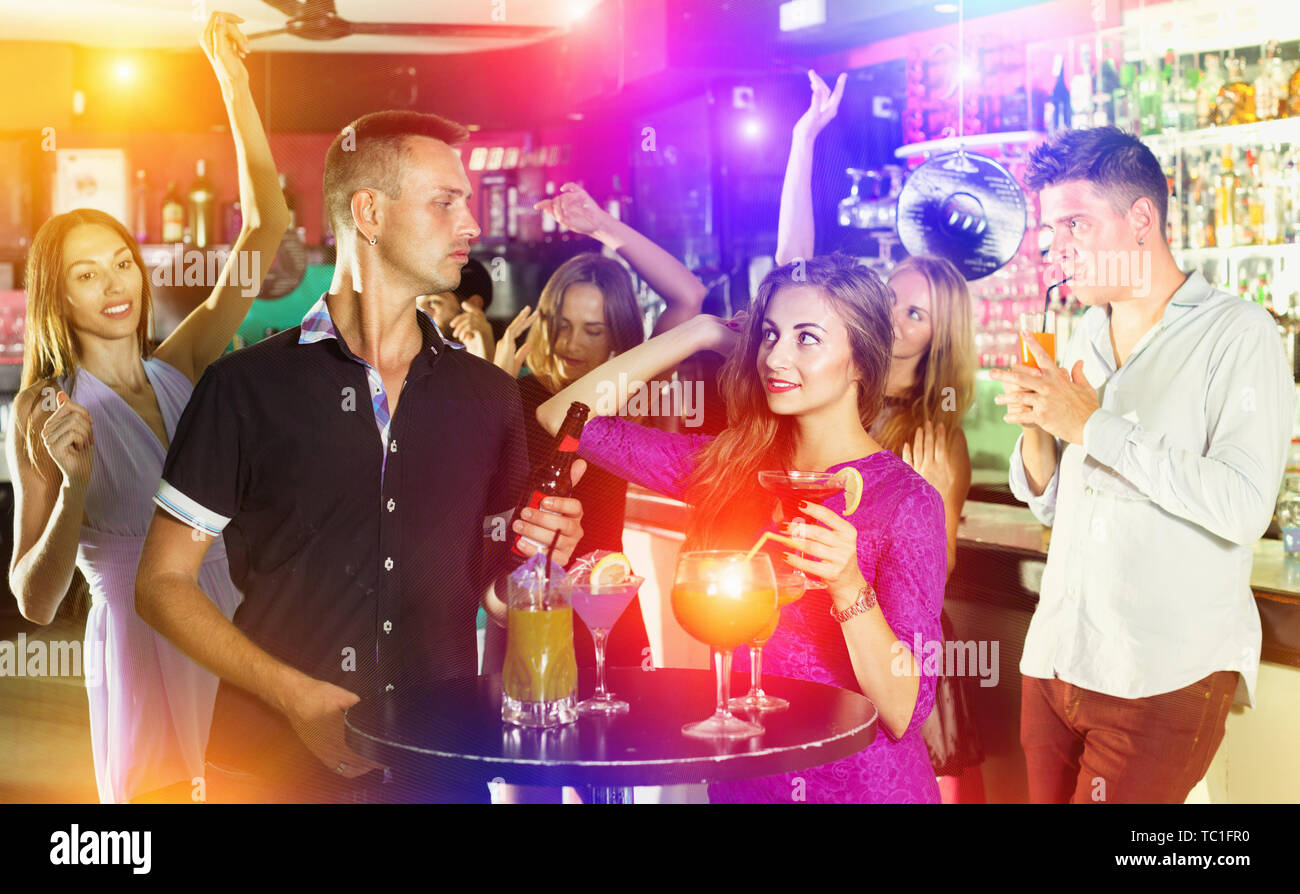 Happy cheerful man with woman are drinking cocktails on corporate party ...