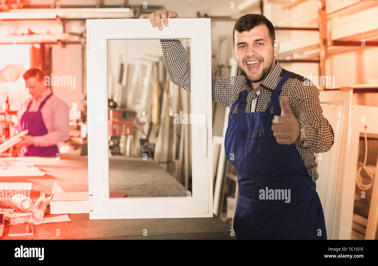 Young male worker is demonstrating the window frame in workshop Stock ...