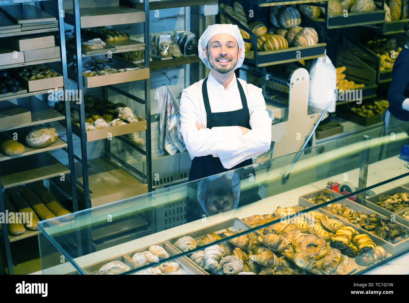 Adult guy is offering fresh tasty bun in bakery Stock Photo - Alamy