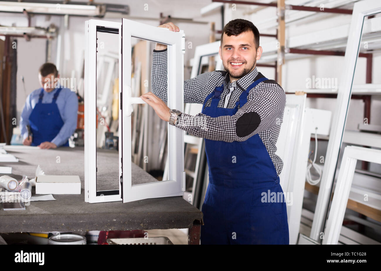 Workman is demonstrating the window frame in workshop Stock Photo - Alamy
