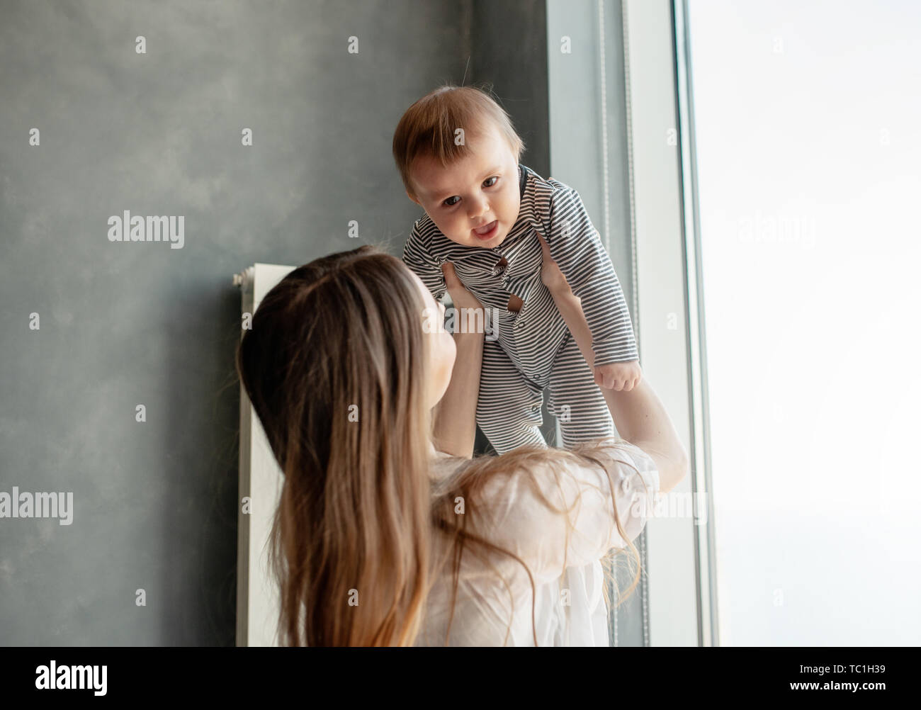 Little child smiling and happy with mom Stock Photo - Alamy