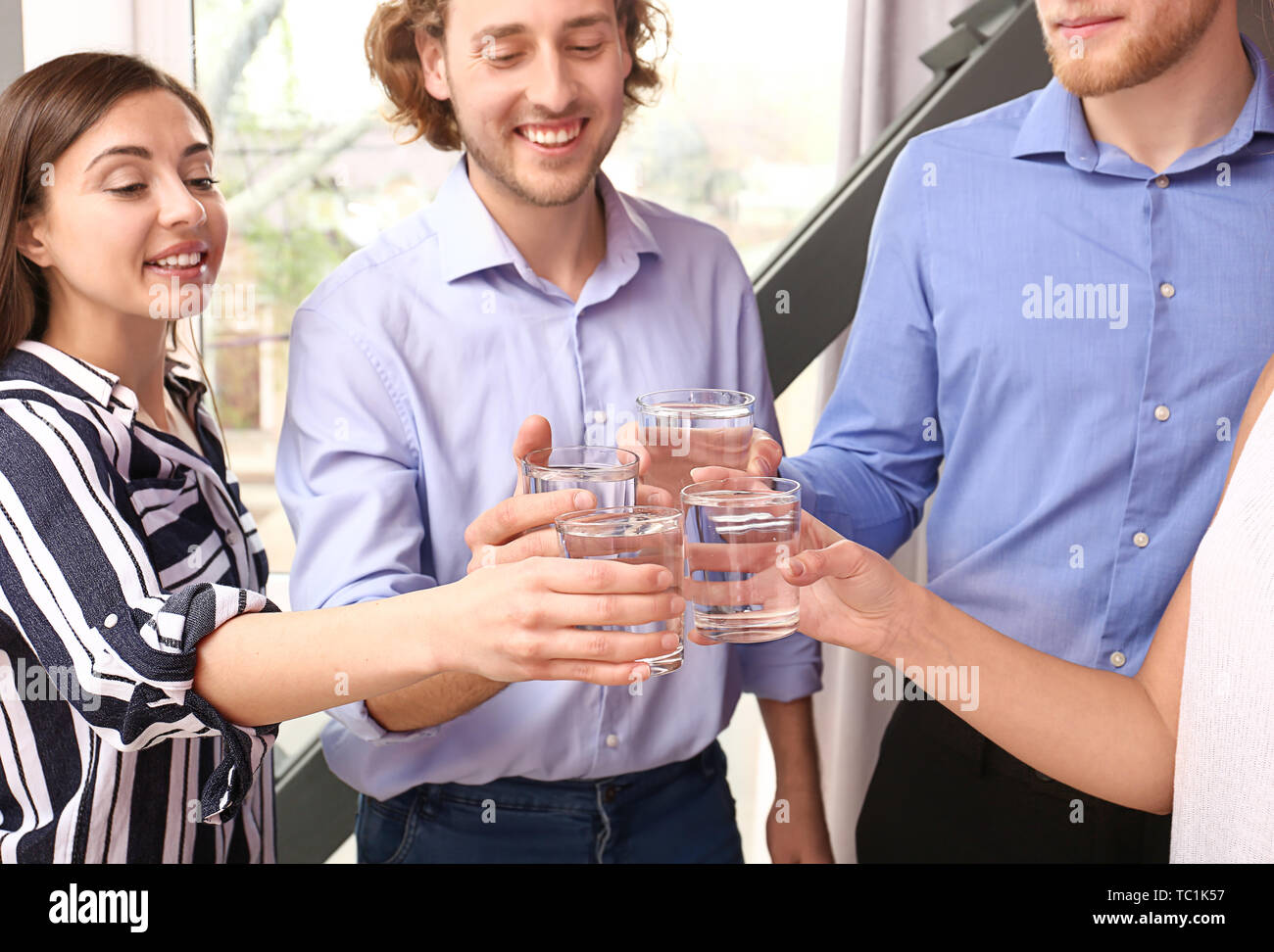 Group of people drinking water indoors Stock Photo - Alamy