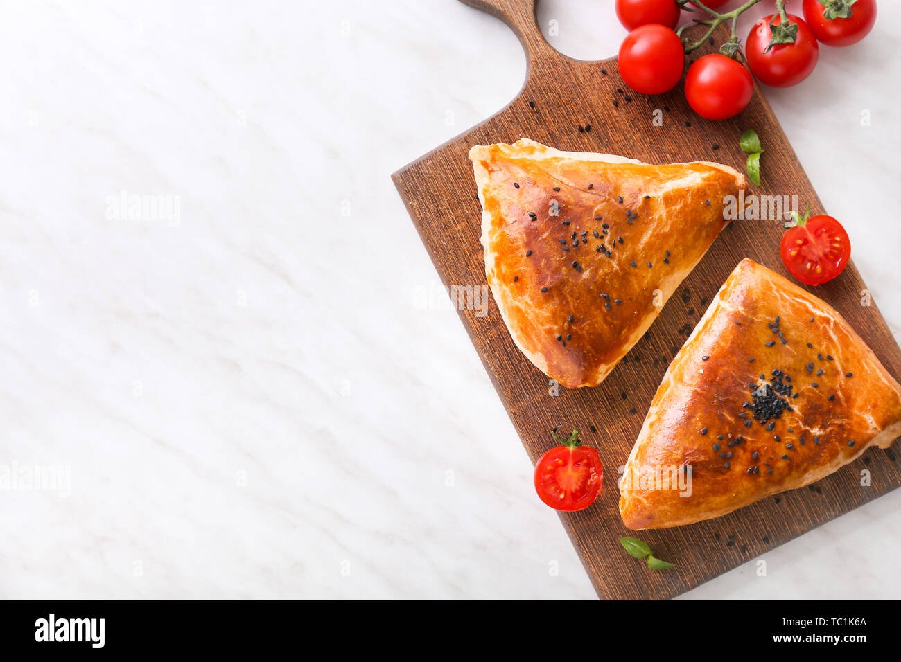 Board with tasty samosas on light table Stock Photo - Alamy