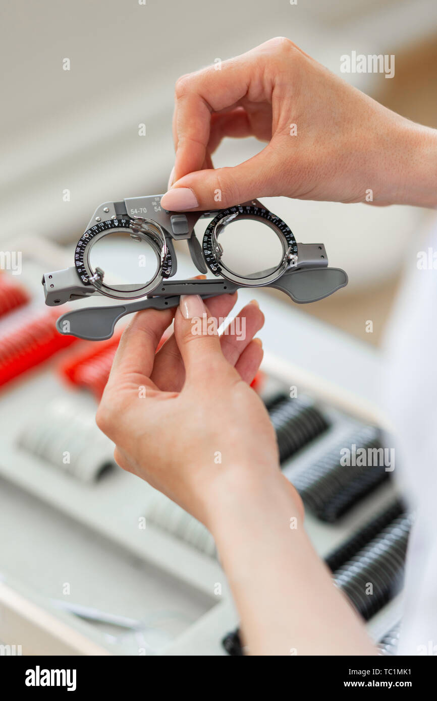 Measuring eyesight. Accurate doctor taking out professional glasses for ...