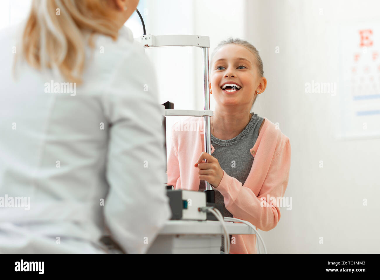 Complicated device. Cheerful excited kid with wide smile talking with ...