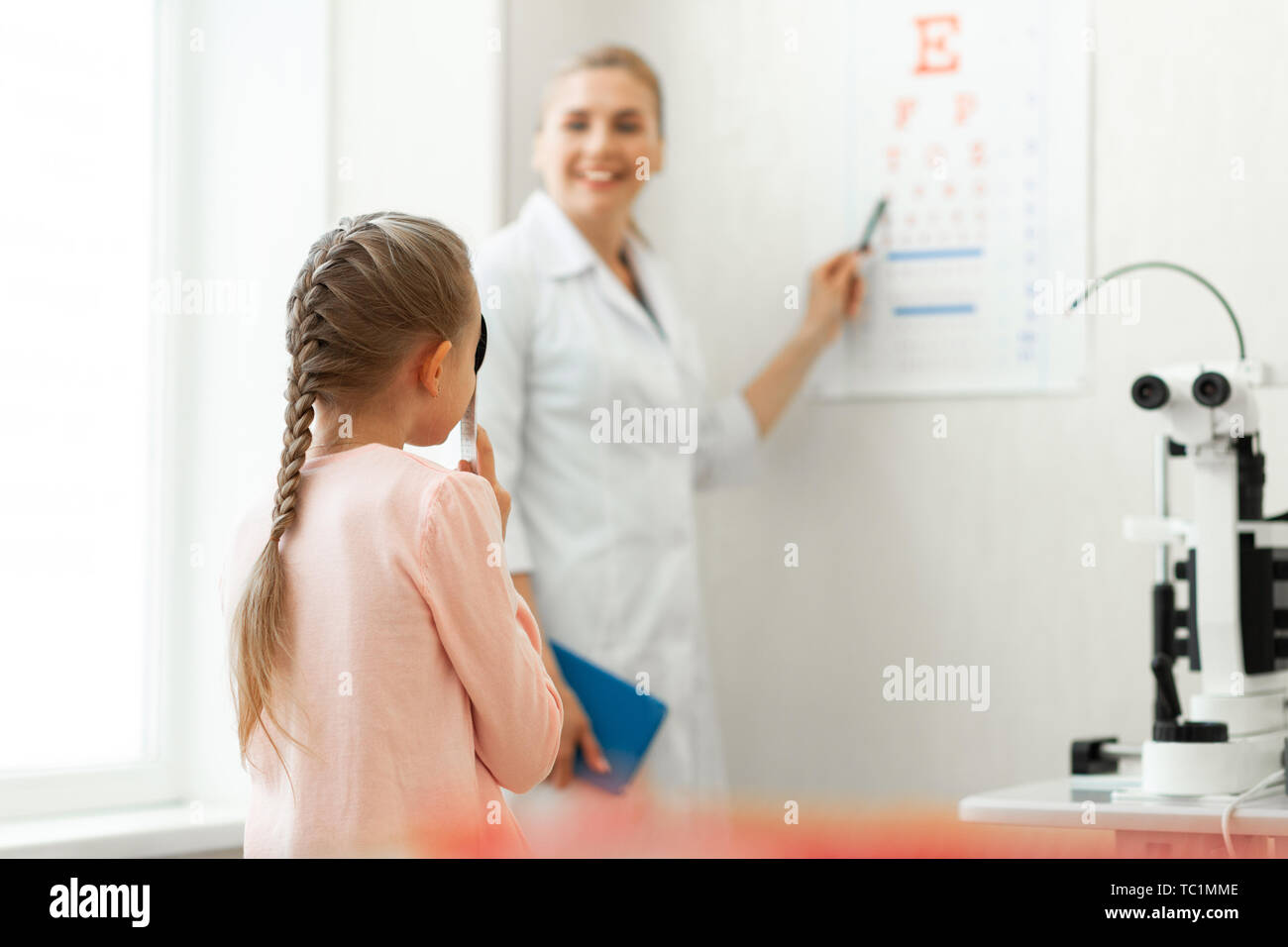 Examining abilities. Young diligent patient closing one eye with ...