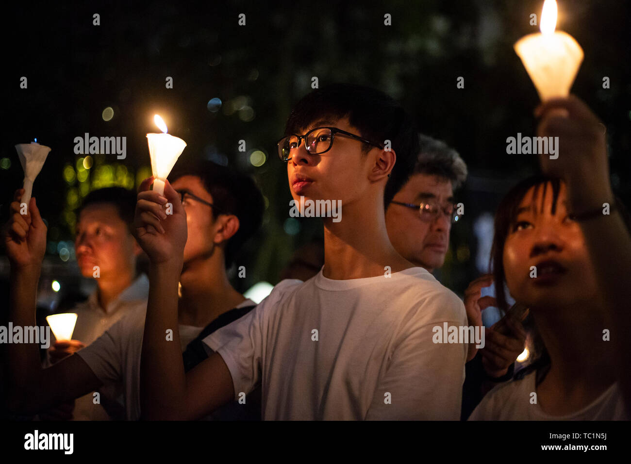 People hold candles during a candlelight vigil at Victoria Park in Hong Kong, to mark the 30th ...