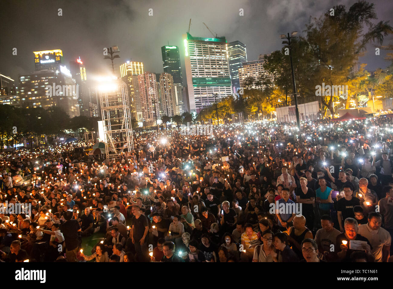 People hold candles during a candlelight vigil at Victoria Park in Hong Kong, to mark the 30th ...