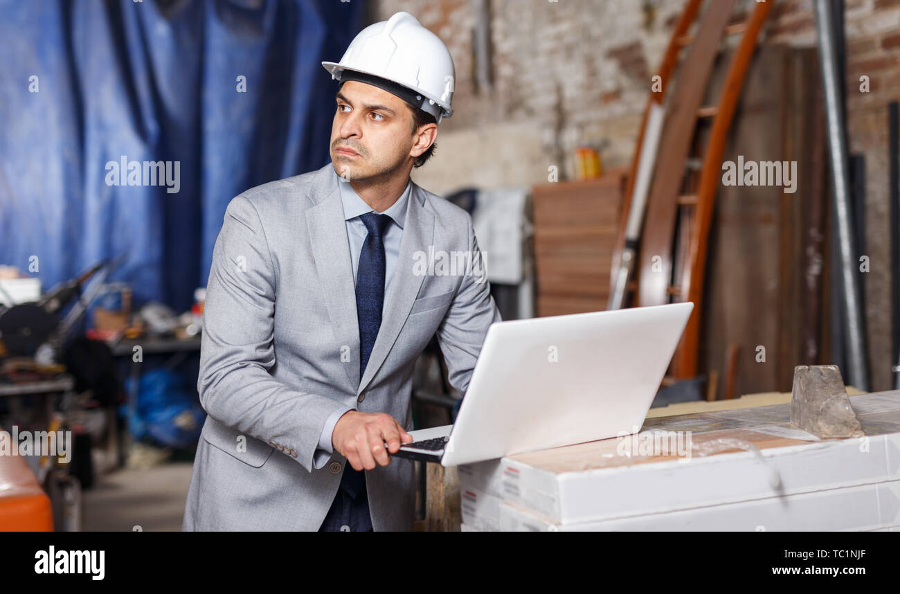 Confident male architect in suit and helmet controlling process of ...