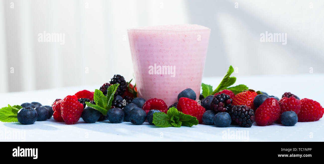 Healthy vitamin milkshake with mix of ripe berries and mint leaves ...