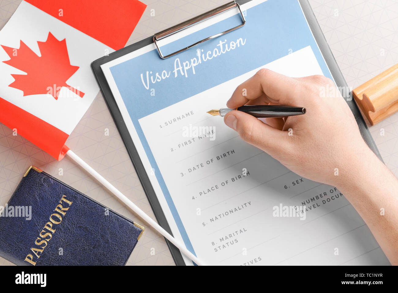 Woman filling in visa application form at table. Concept of immigration ...