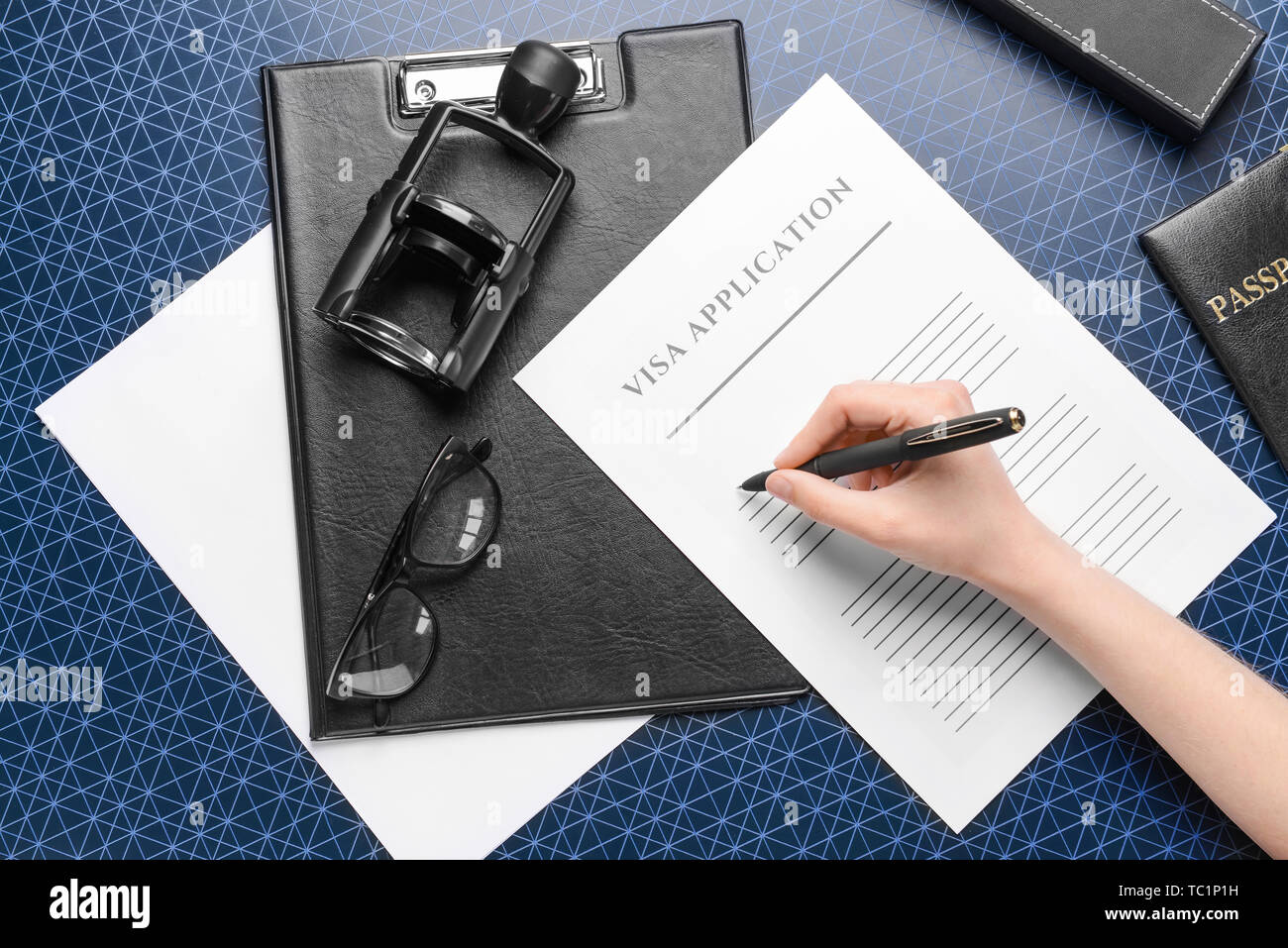 Woman filling in visa application form at table. Concept of immigration ...