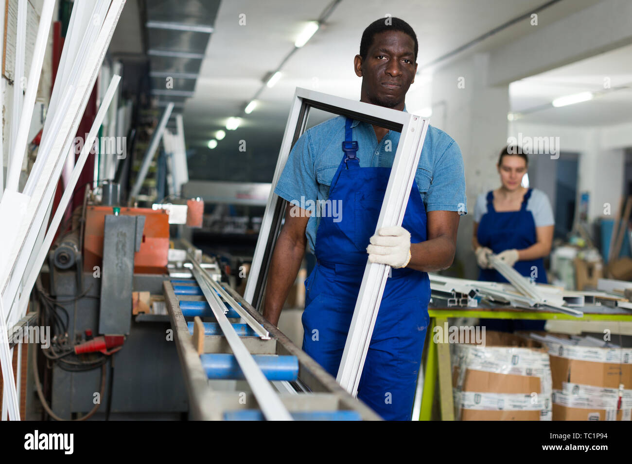 Portrait of man worker who is standing with window frame in the pvc ...