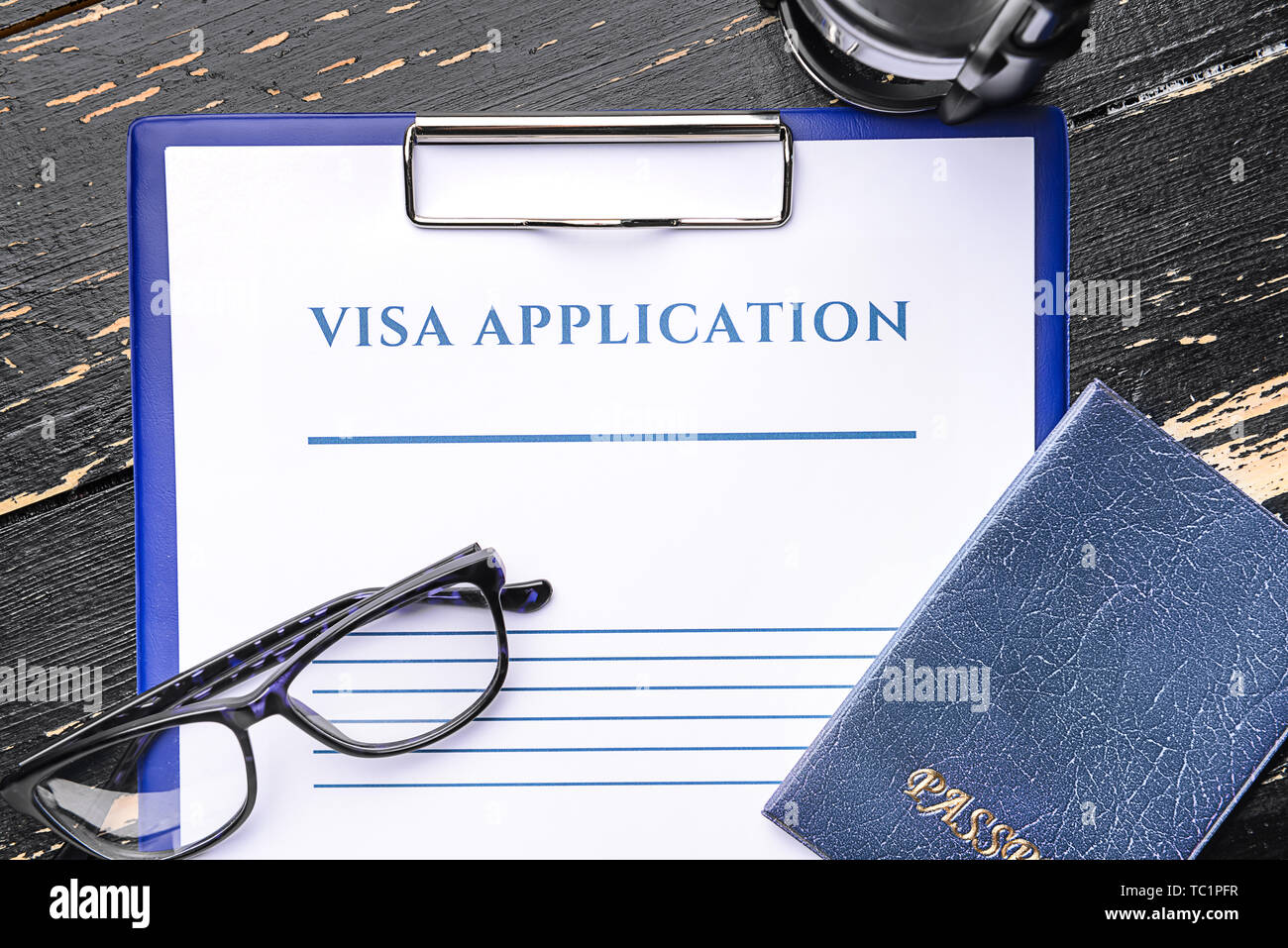 Visa application form, passport and stamp on table. Concept of ...