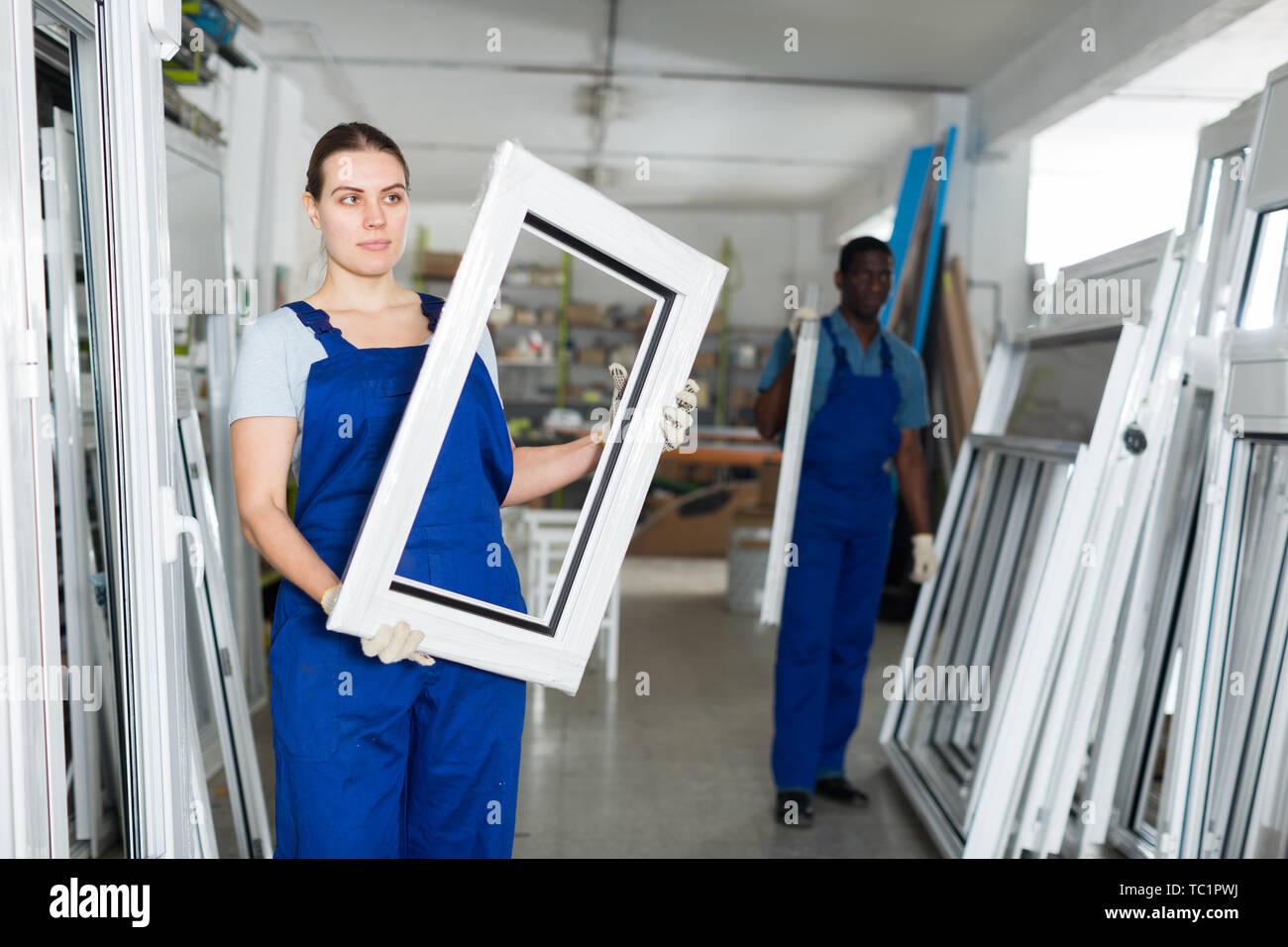Female master is working with window frame in the window workshop Stock ...