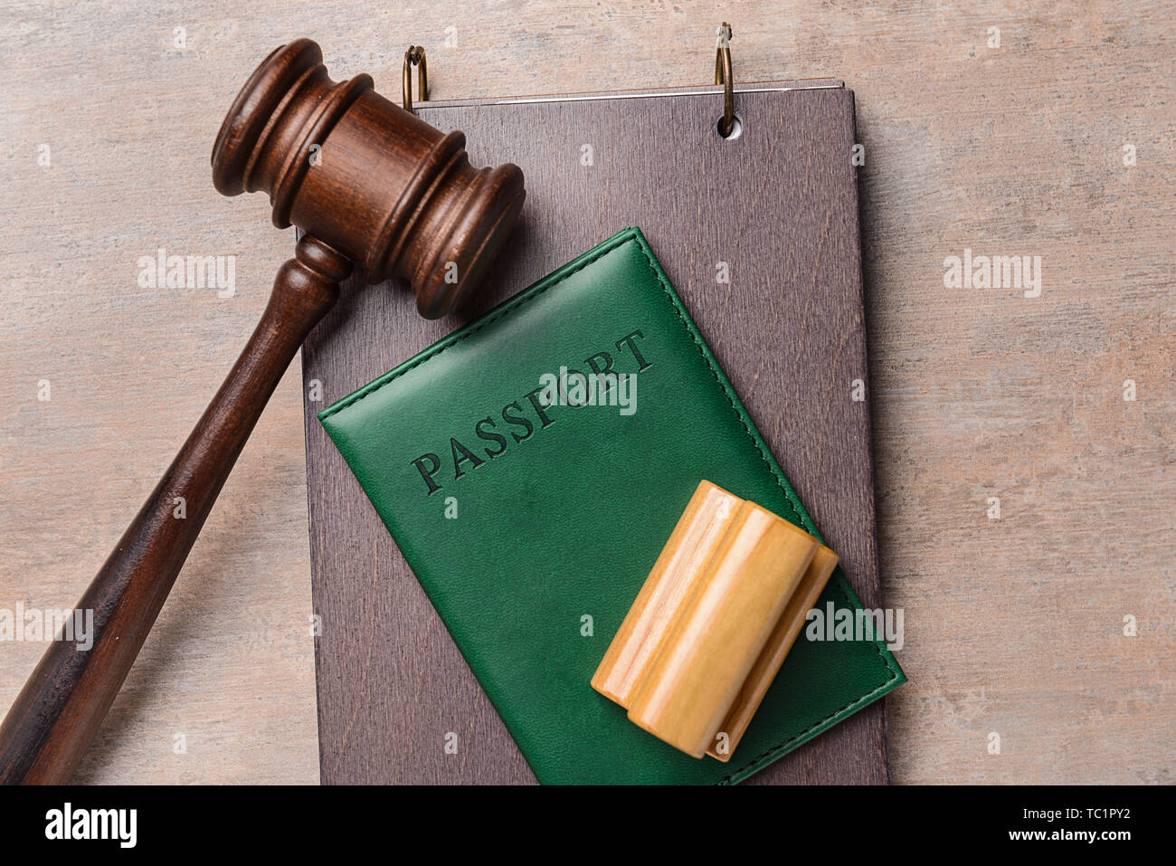 Judge's gavel, notebook, stamp and passport on table. Immigration law ...