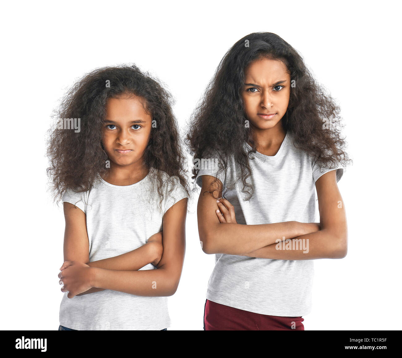Offended African-American girls on white background Stock Photo - Alamy
