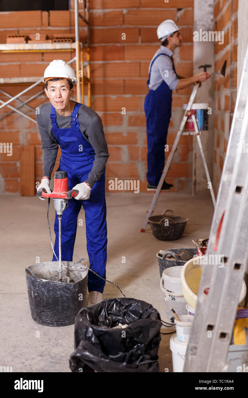 Portrait of two professional builders in process of repair at private ...