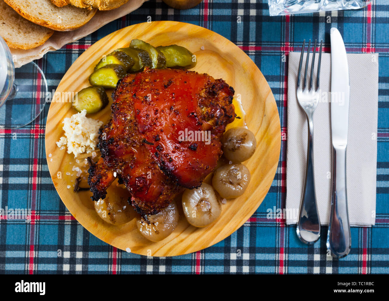 Oven baked pork knuckle with boiled onions and pickled cucumbers Stock ...