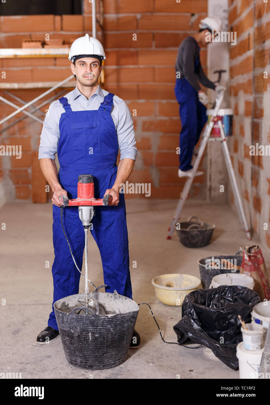 Portrait of two professional builders in process of repair at private ...