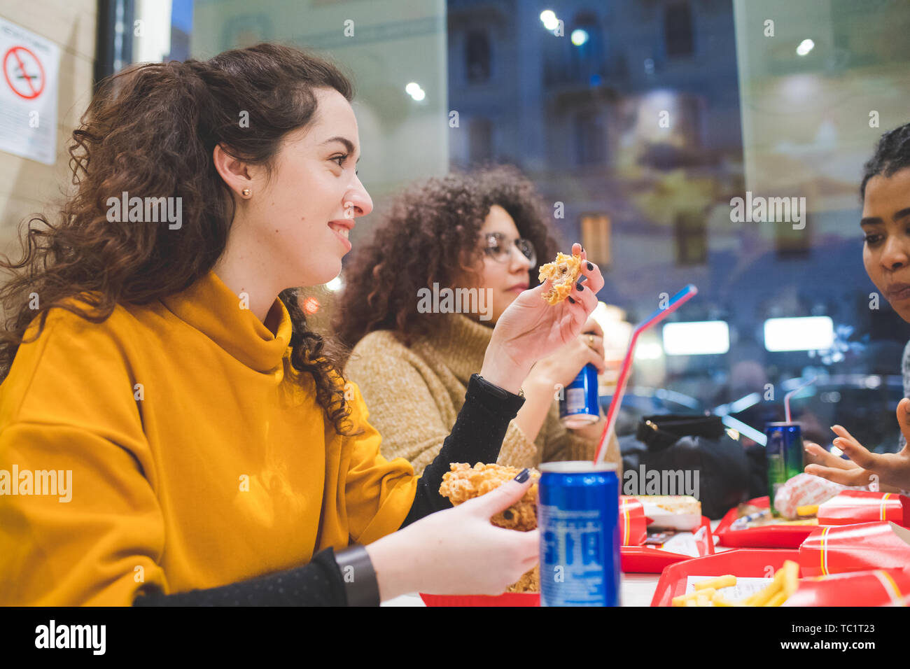 group of young women eating together and having conversation ...