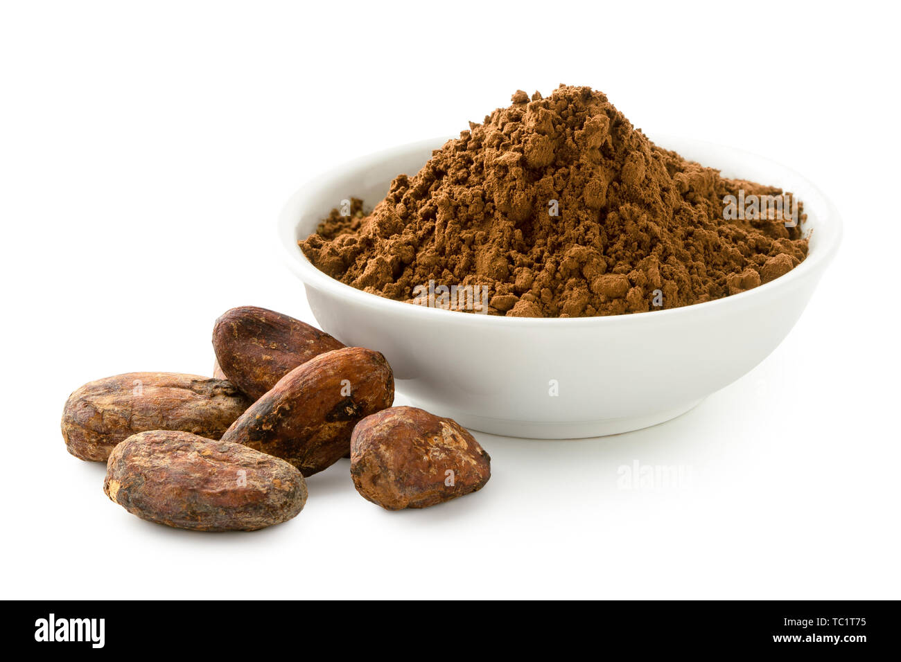 Cocoa powder in a white ceramic bowl next to roasted unpeeled cocoa ...