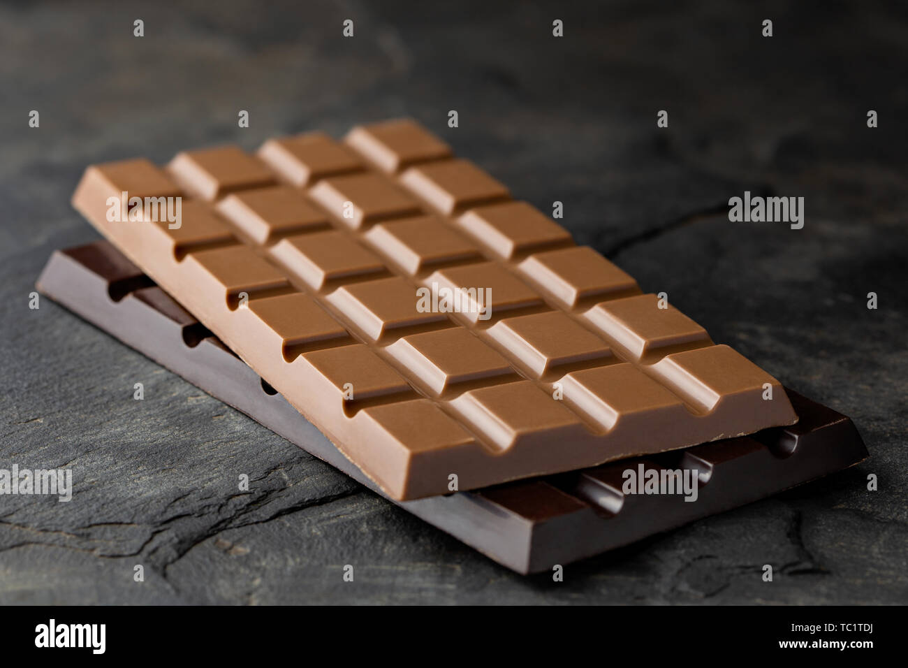 A slab of milk chocolate on top of a slab of dark chocolate isolated on ...