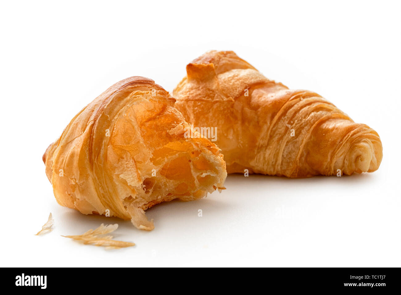 One and half baked plain croissants isolated on white Stock Photo - Alamy