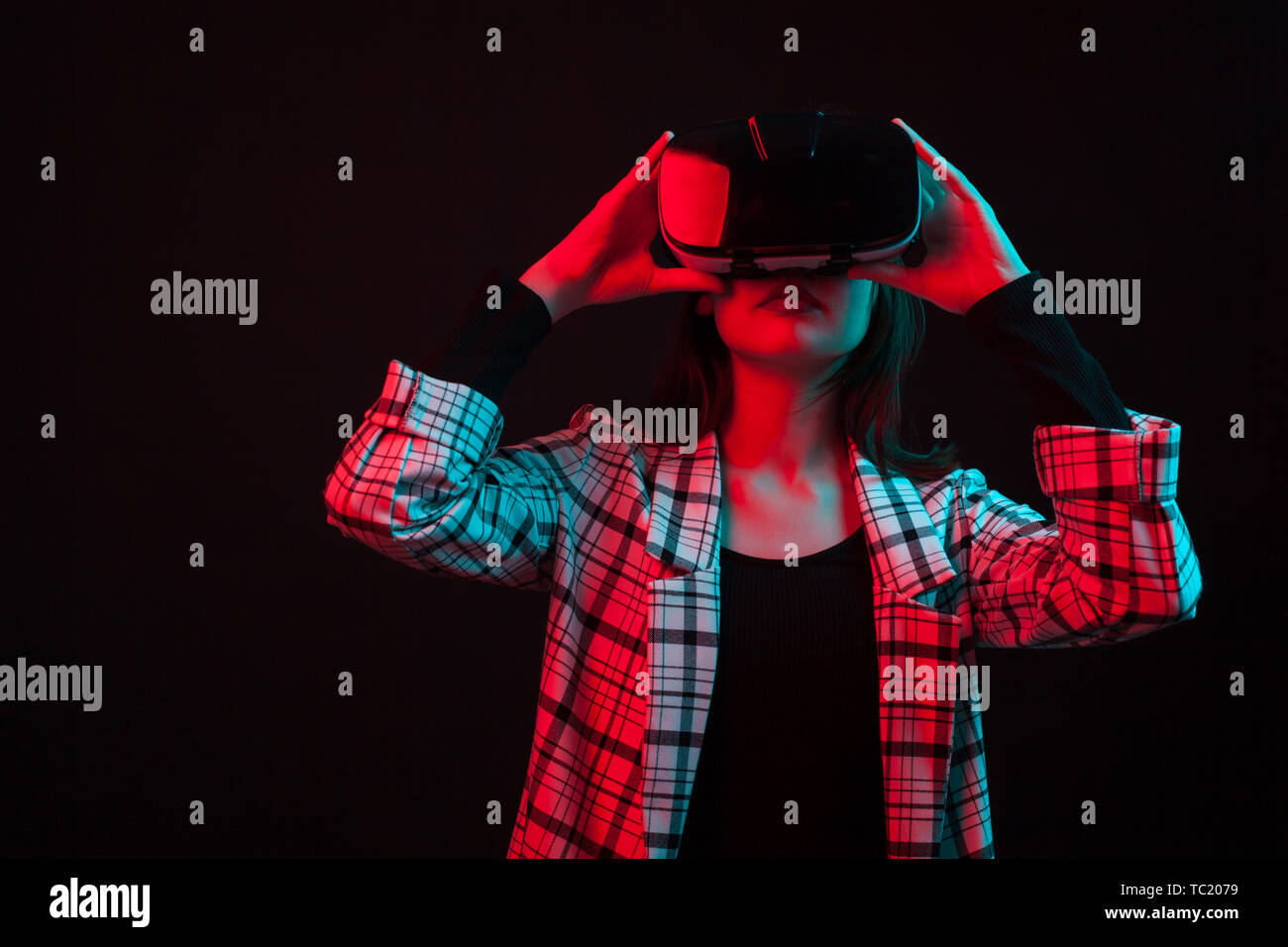 Beautiful young girl using modern virtual technology in studio over ...