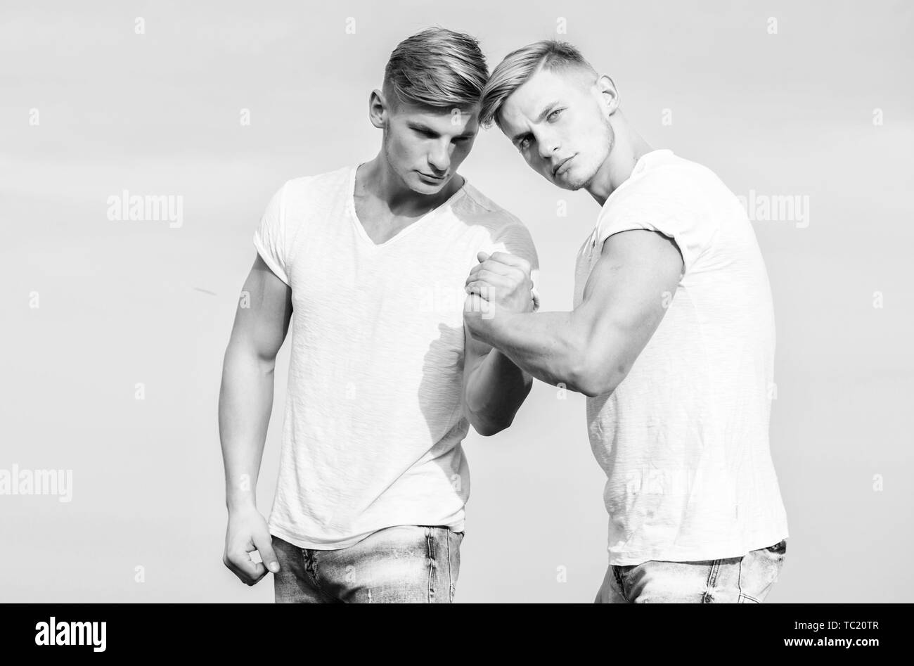 Men twins brothers muscular guys in white shirts sky background ...