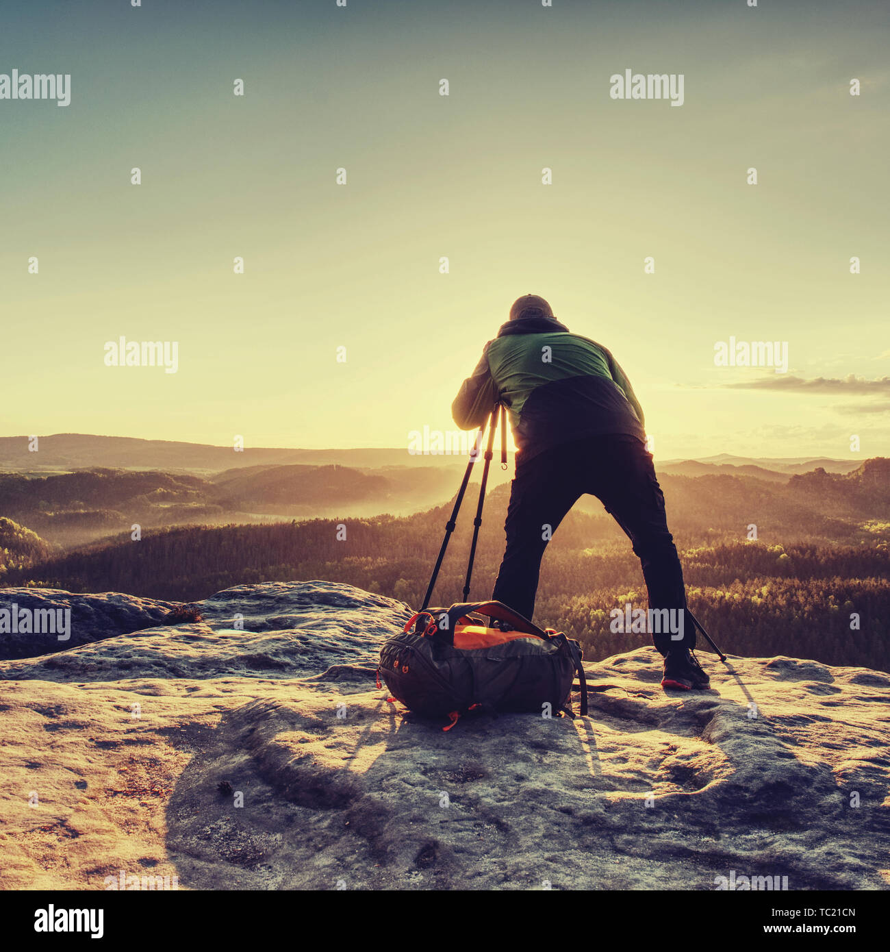 Picture shooting process in nature. Artist holding camera on tripod and ...